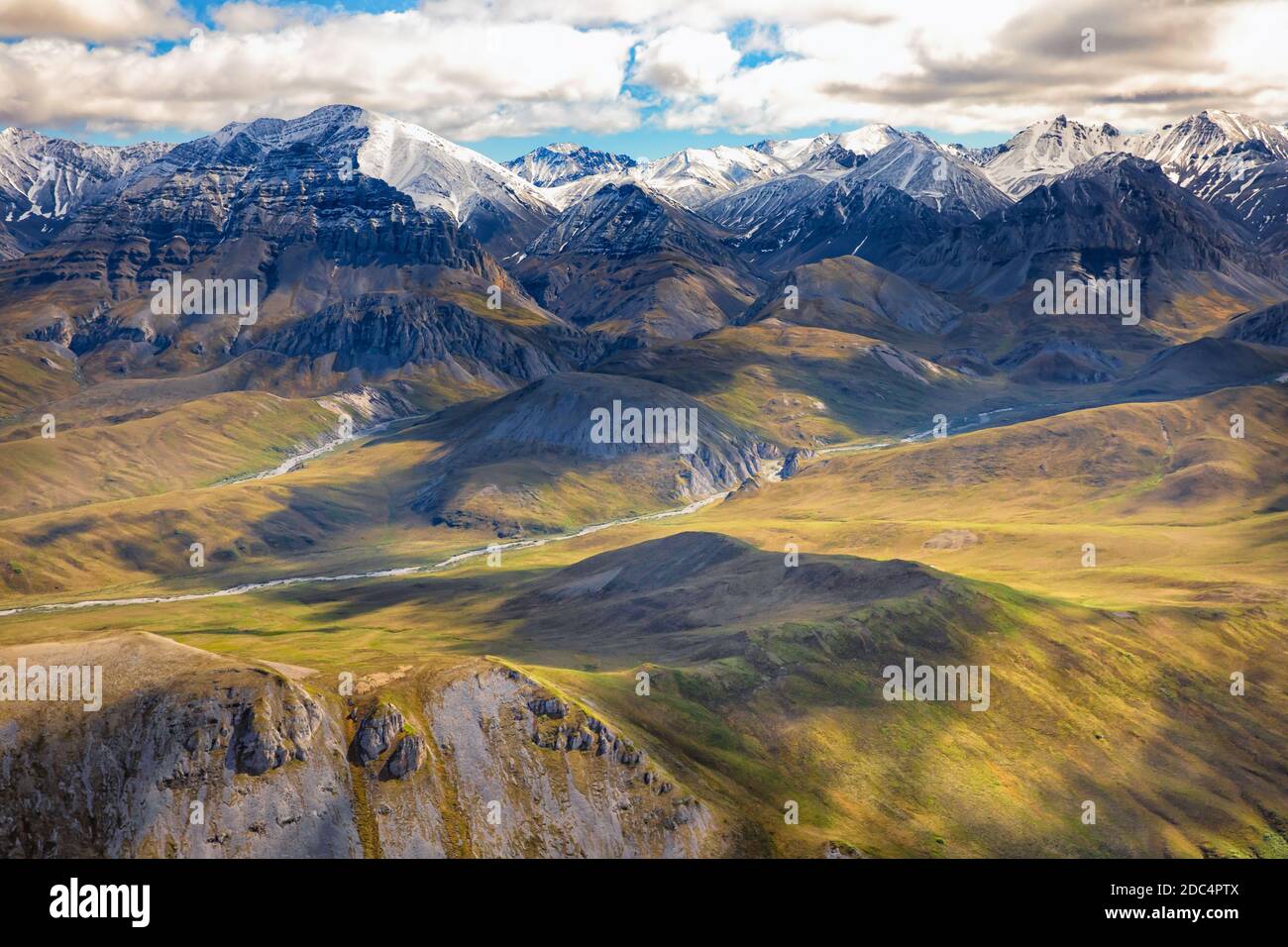 Aerial view of the snowcapped Brooks Range and tundra in the Arctic ...
