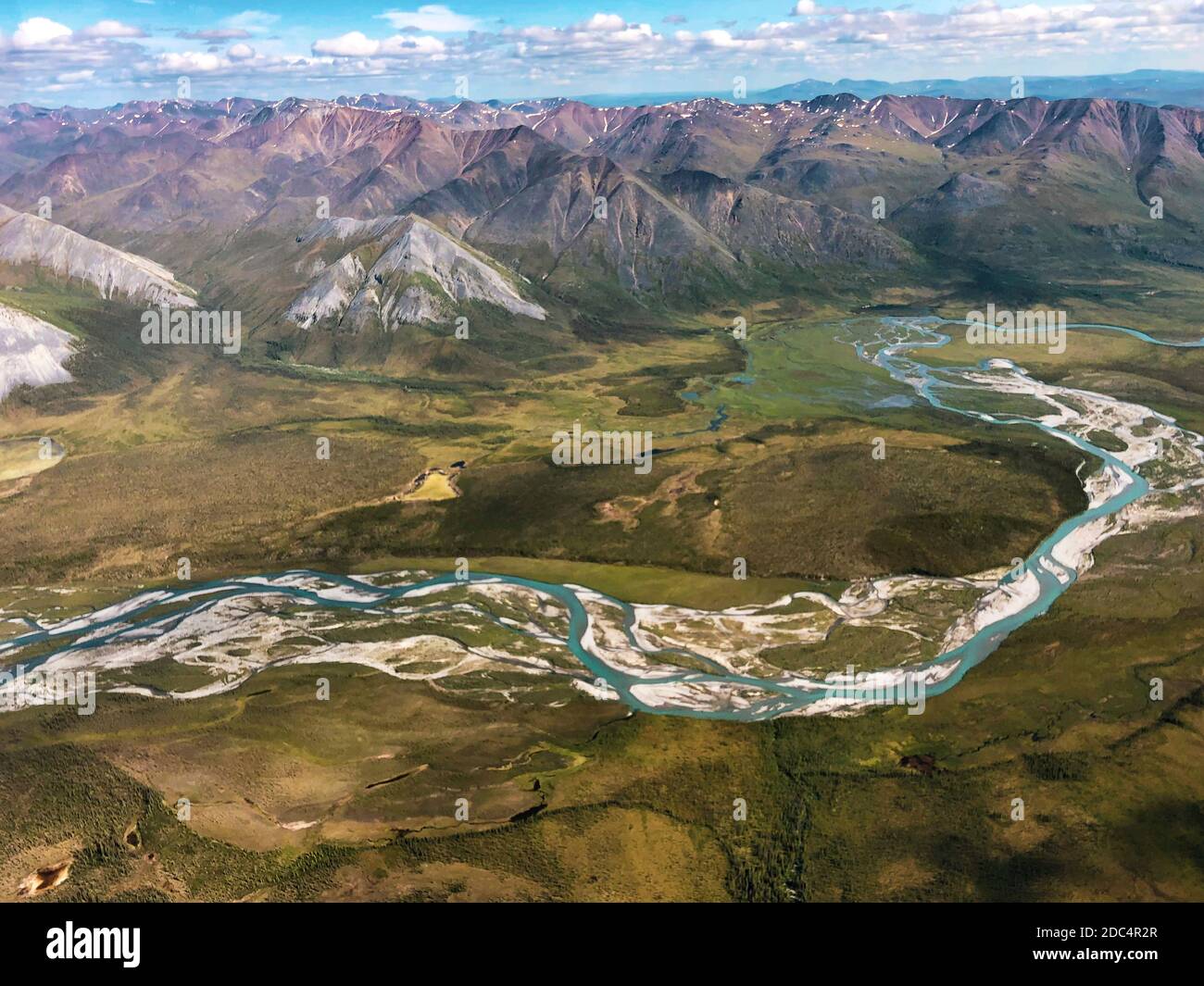 Aerial view of the snowcapped Brooks Range and tundra in the Arctic ...