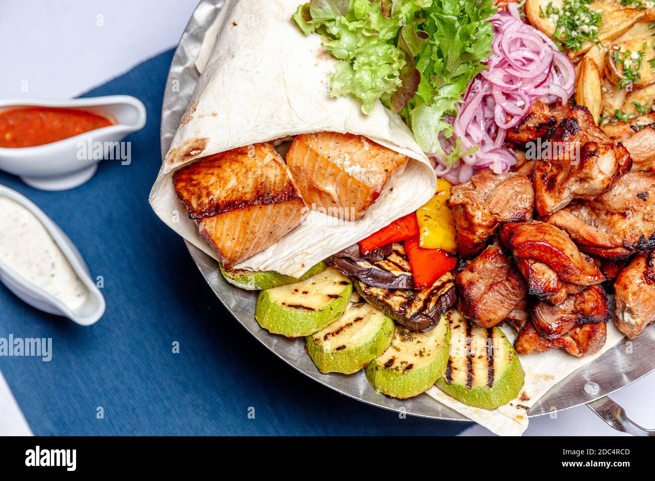 Mixed grill meat fried vegetables and grilled salmon fish fillets ...