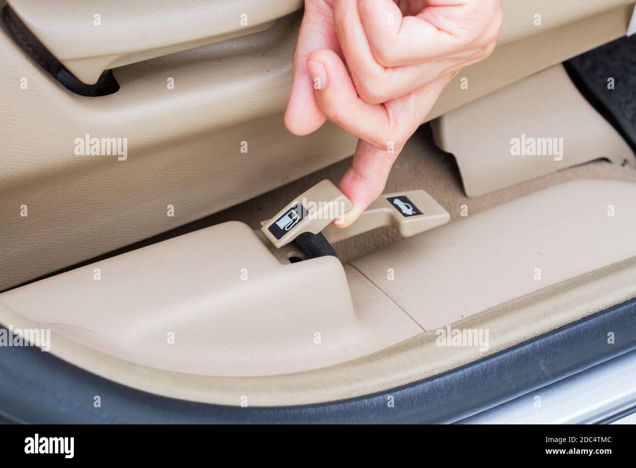 closeup hand pulling fuel door open button in a car Stock Photo - Alamy