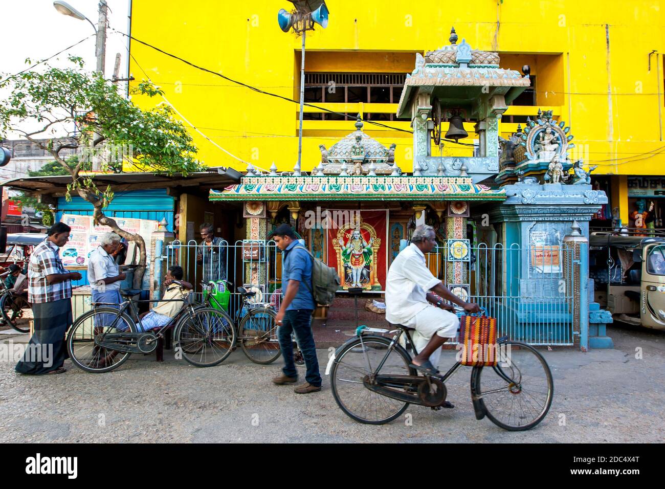 A man cycles past a small Hindu Temple next to the Jaffna bus station ...