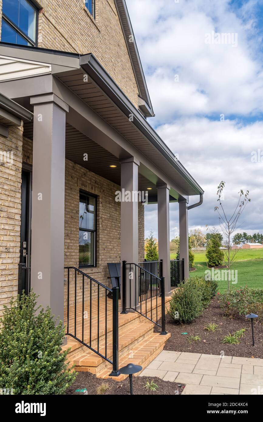Covered porch with brown columns Stock Photo - Alamy