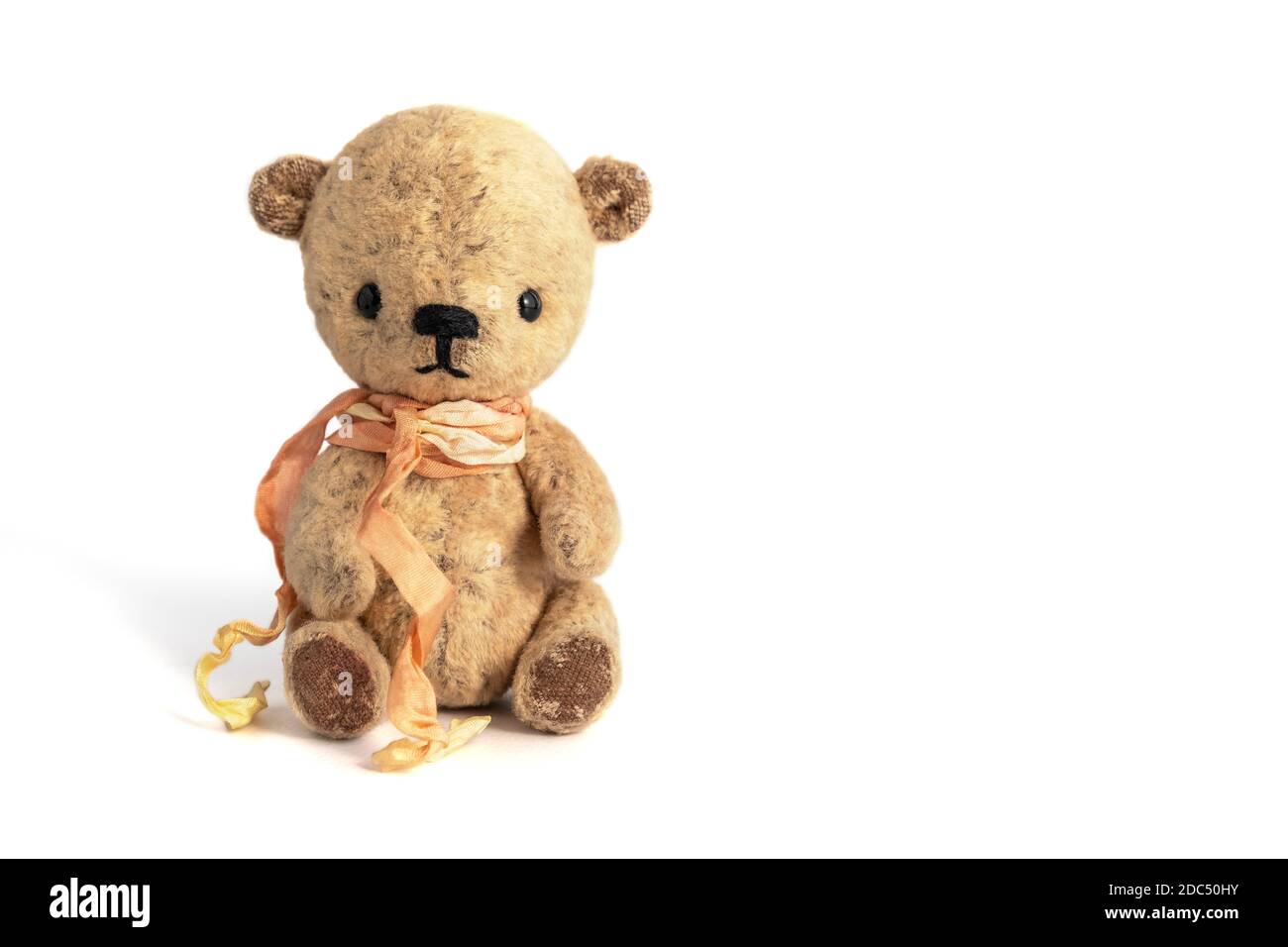 Vintage handmade teddy bear with a ribbon around the neck sits on a ...