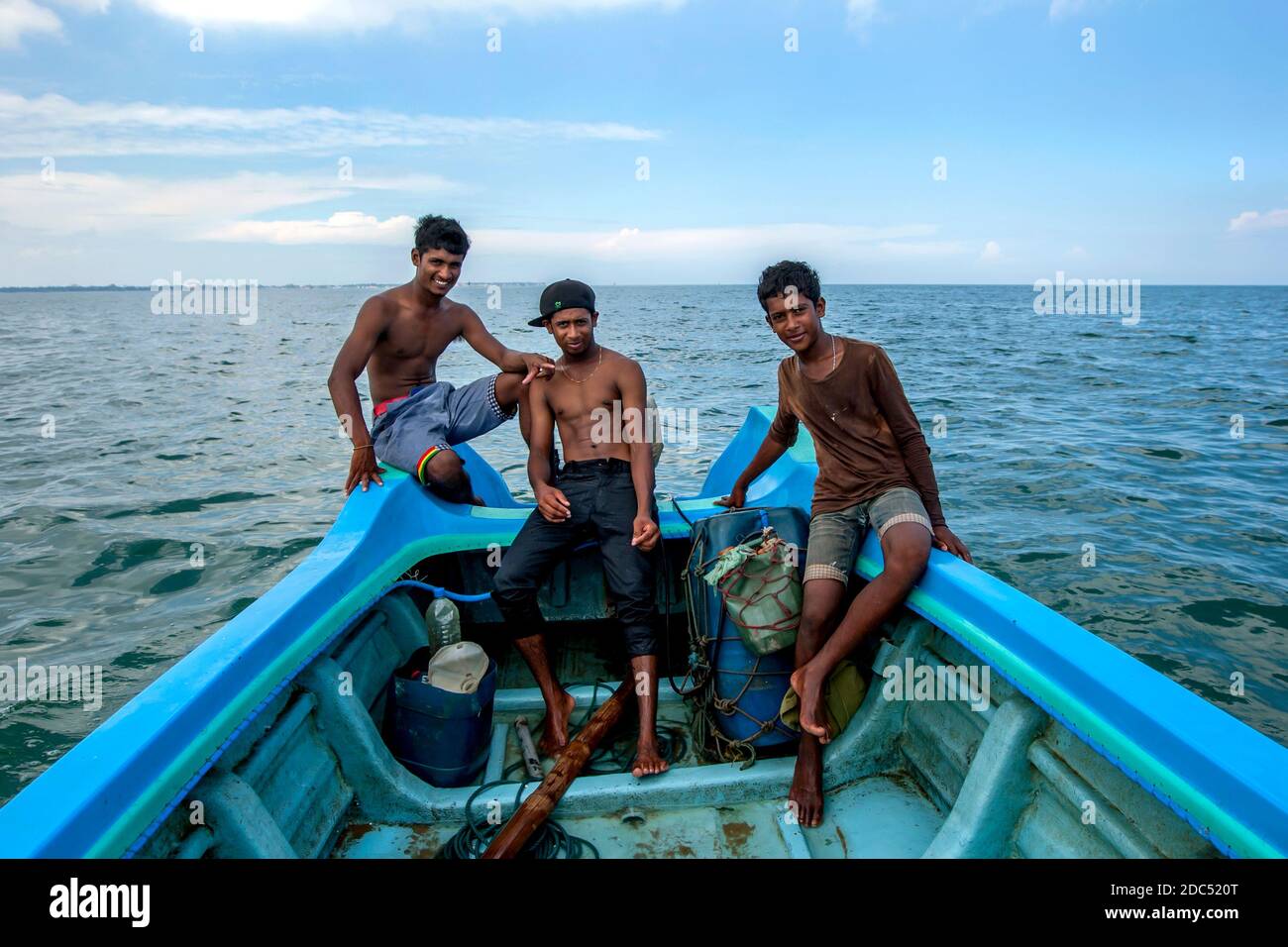 Three fishing brothers sit in their boat in the Indian Ocean off the ...