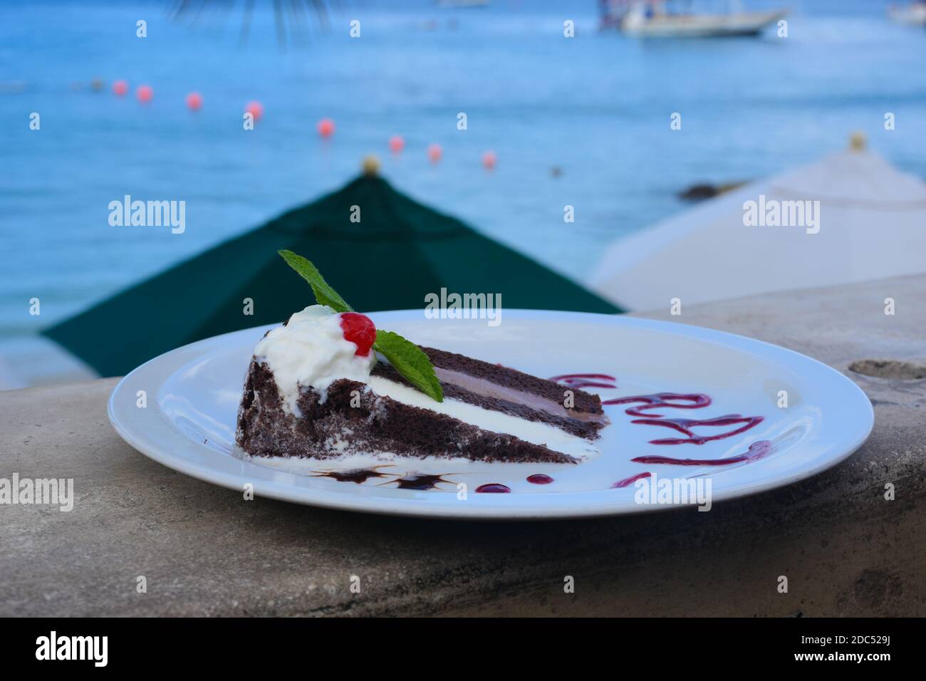 Chocolate cake with icing overlooking ocean paradise Stock Photo - Alamy