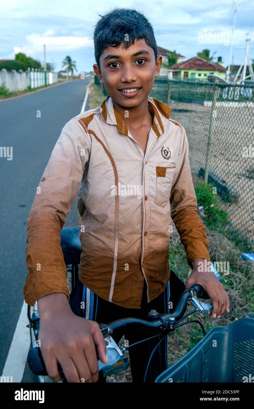 A Muslim boy standing with his bike on the roadside at Pottuvil on the ...