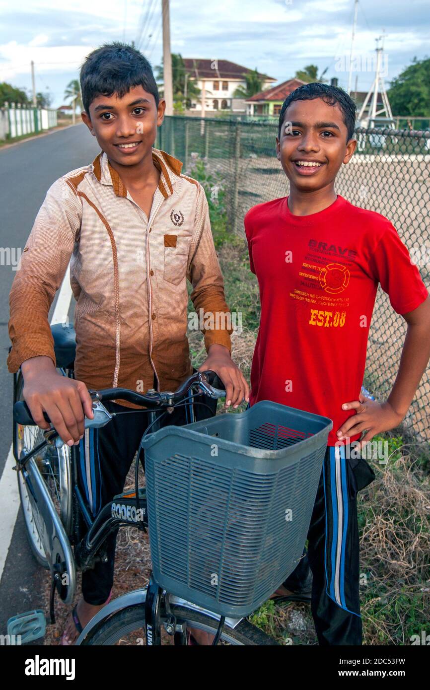 Muslim boys stand with their bike on the roadside at Pottuvil on the ...