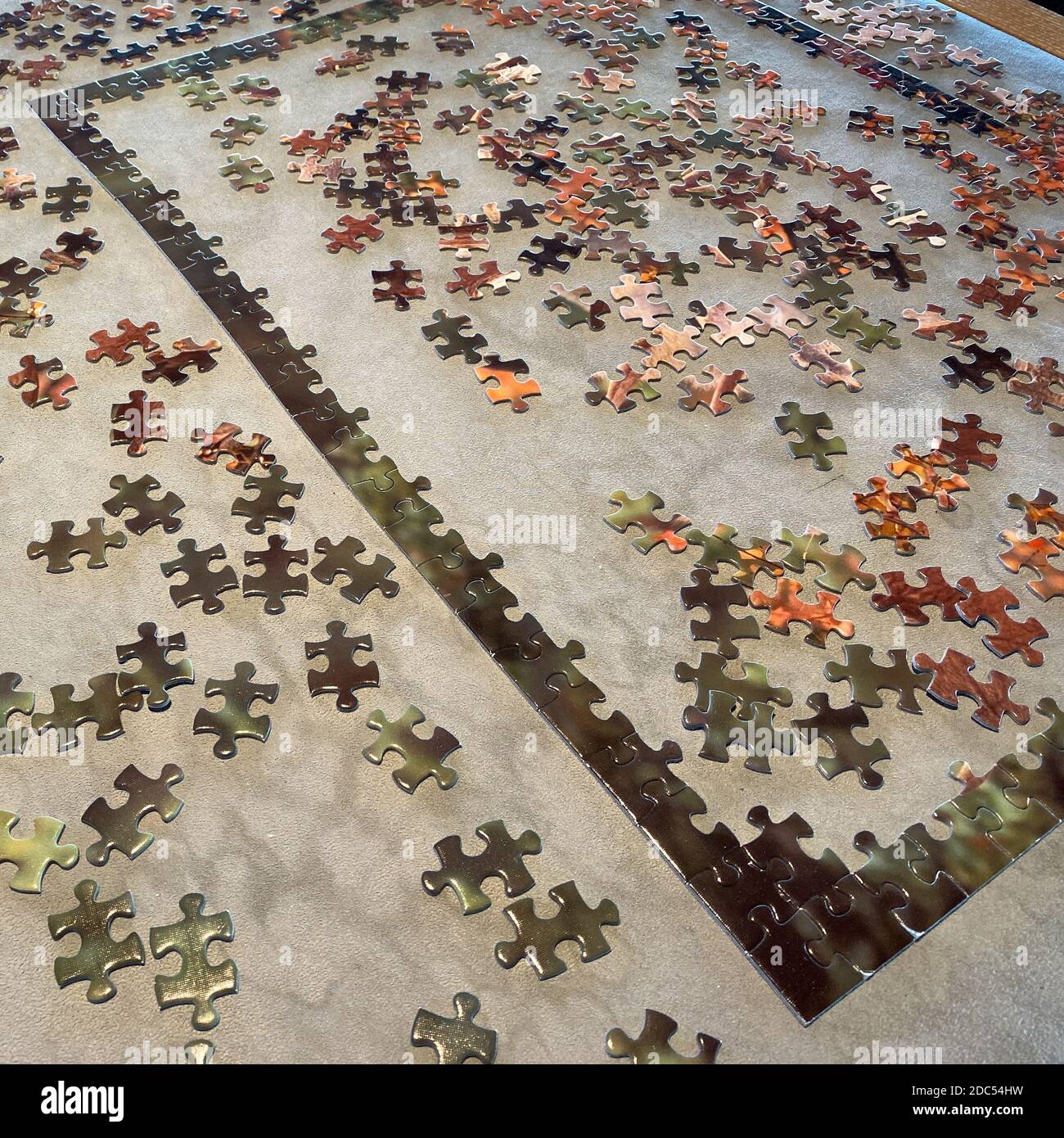 A colorful puzzle with the edges completed on a leather looking table ...