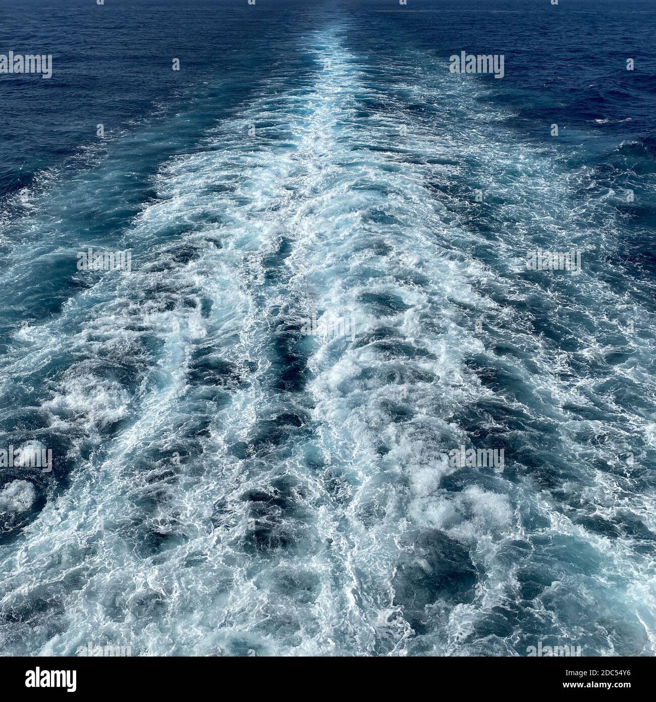 Cruise ship wake on a beautiful sunny day with white clouds and ...