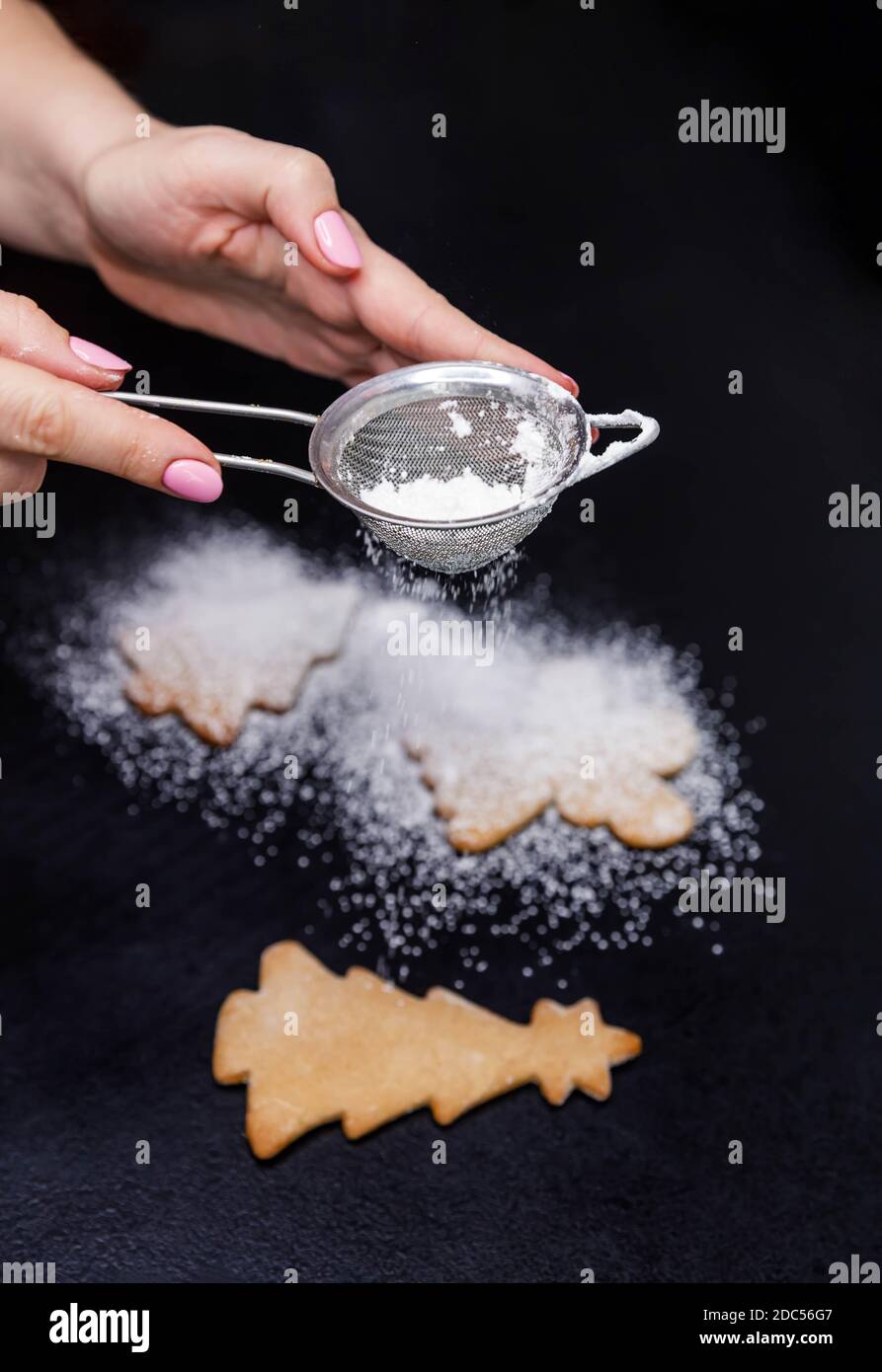 Sifting powdered sugar or flour on cookies. Homemade baking Stock Photo ...