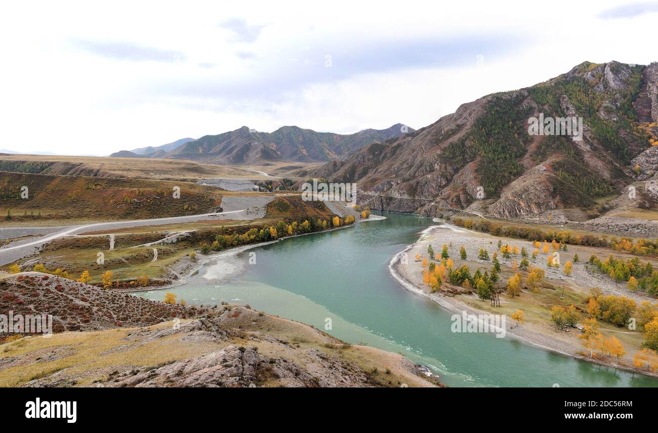 The confluence of two mountain turquoise rivers in a picturesque valley ...