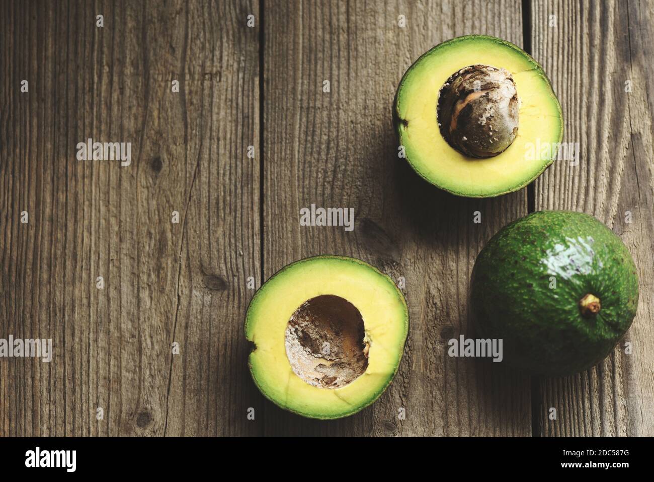 Avocado fruit and slice cut halfs avocado on wooden background, Fruits ...