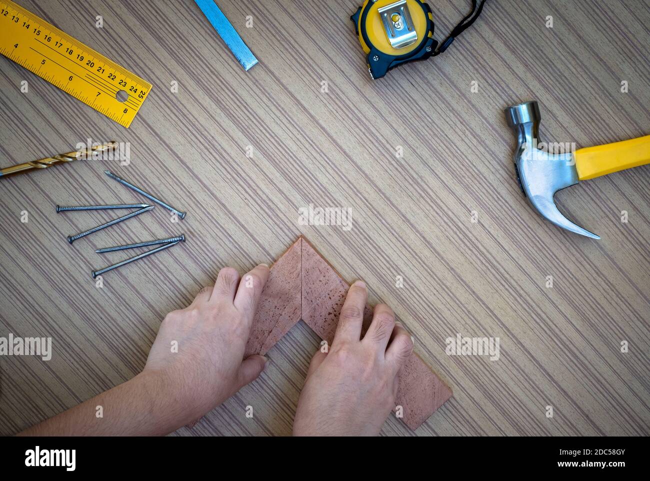Carpenter hands measuring wood plank with a set collection of working ...