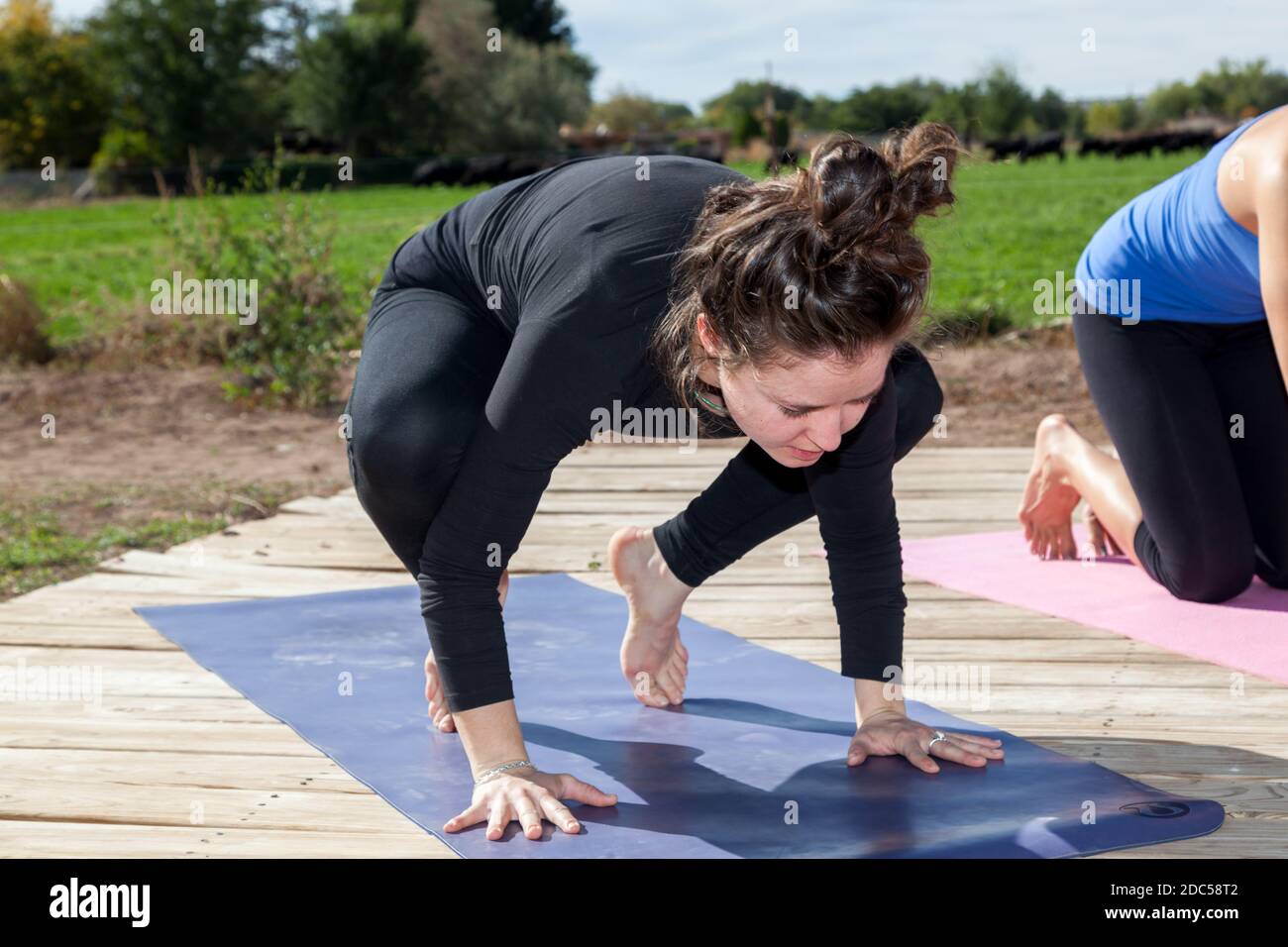 A woman holds an intricate pose of flexibility and balance at an ...
