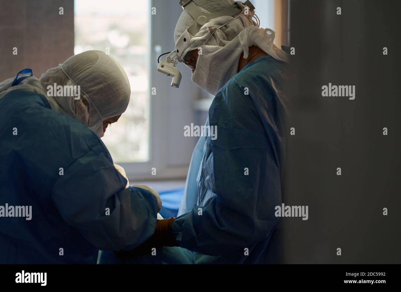 Surgery. Surgeons are working. View from behind the operating room door ...