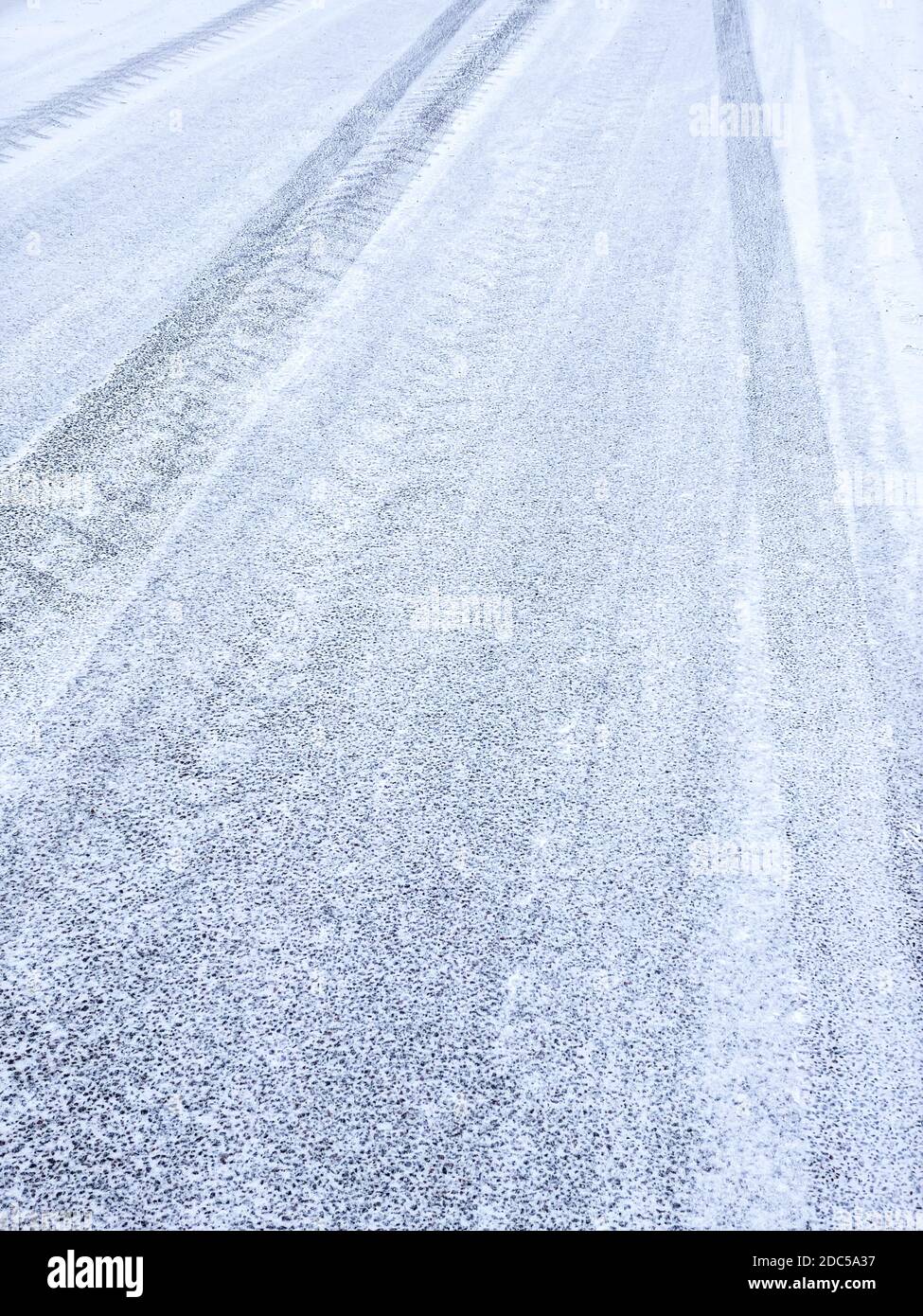 asphalt road covered with snow and tire tracks. roadway after snowfall ...