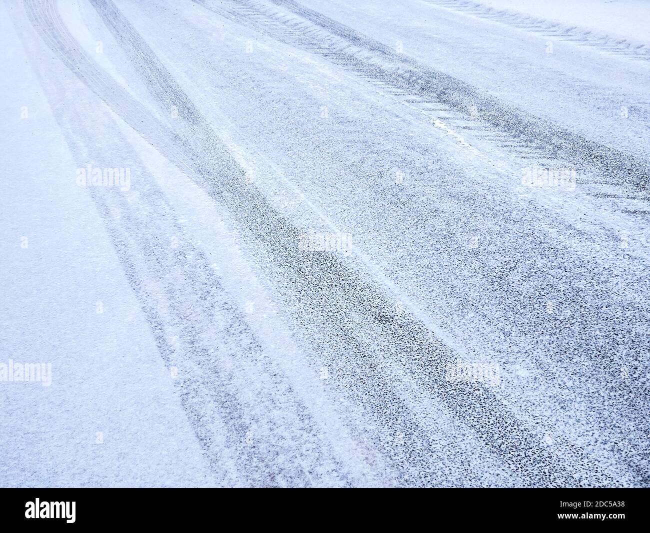 road in winter. asphalt covered with snow and imprints of tire tracks ...