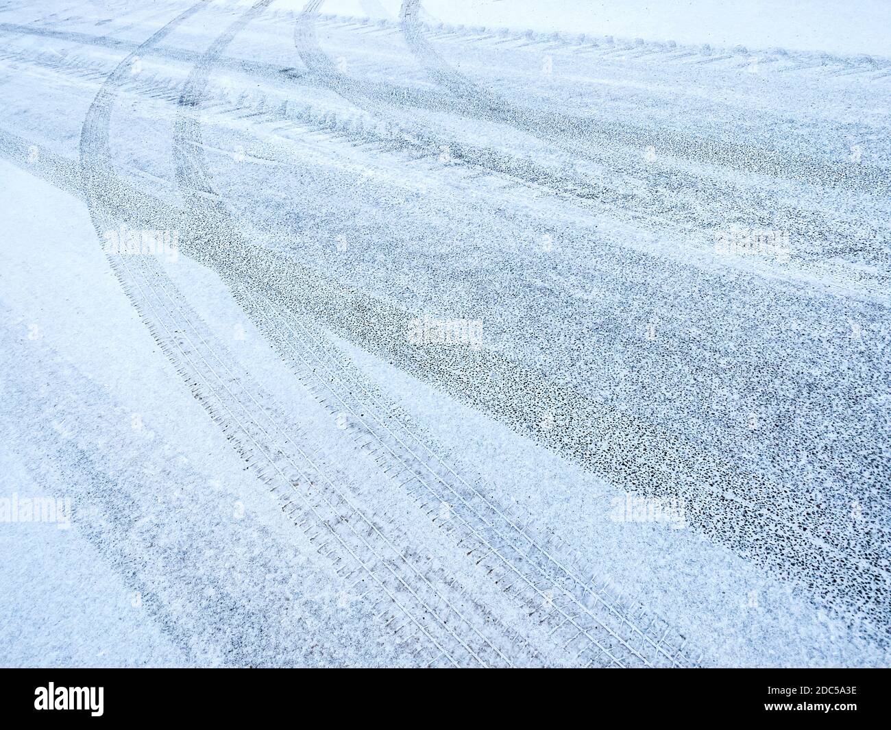 snowy asphalt road background with crossing of tires imprints Stock ...