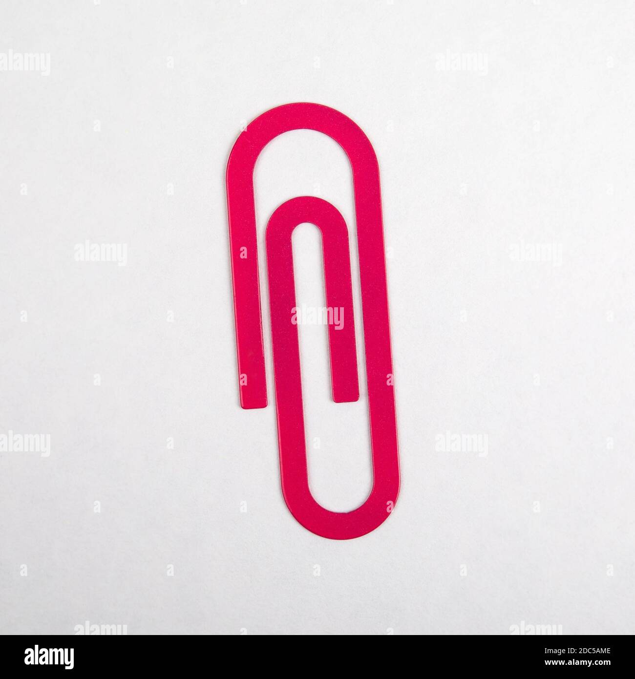 Pink paper clip on a white background. Stationery and office supplies ...