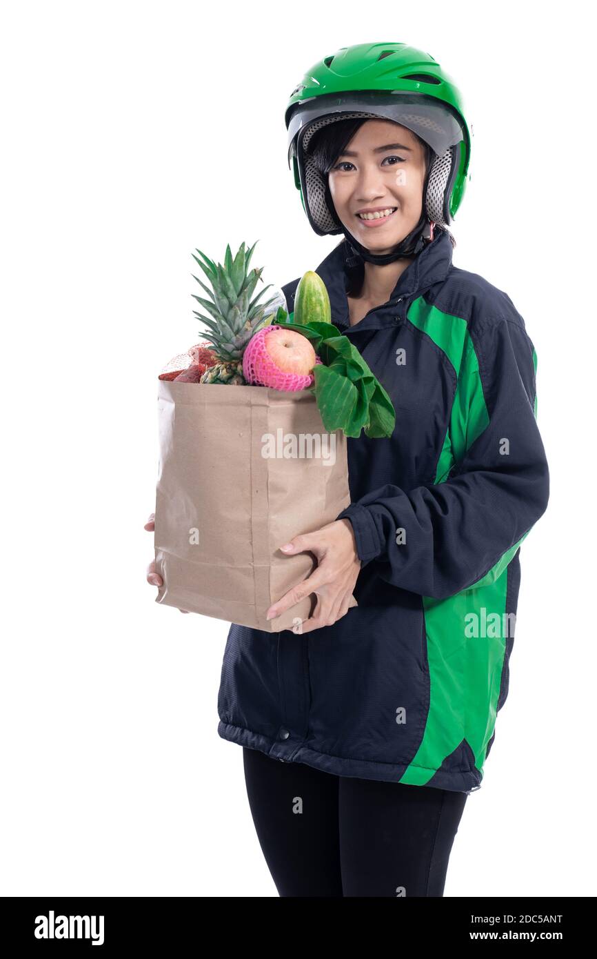 female uber delivery courier wearing helmet bring groceries in the bag ...