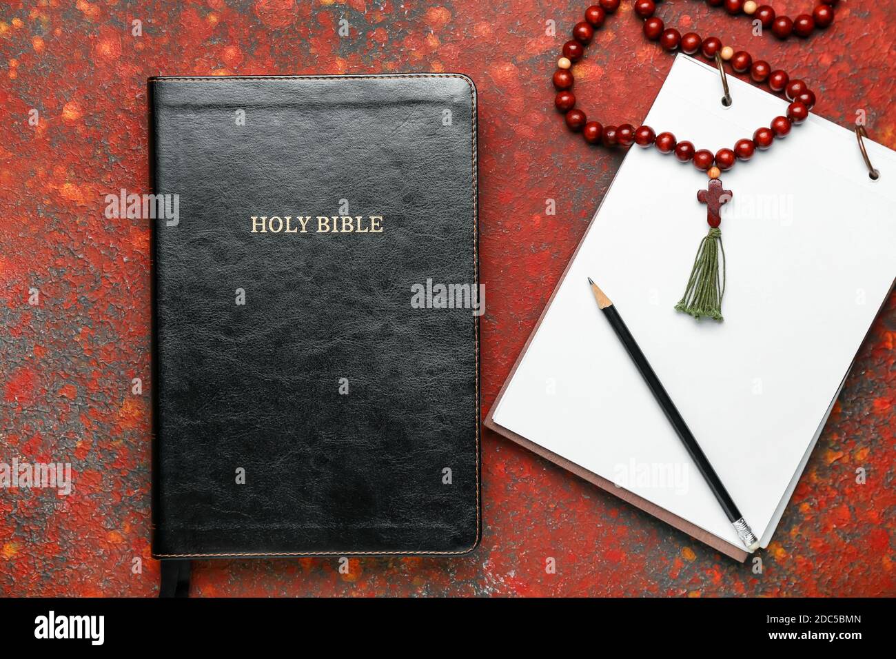 Hole Bible, notebook and rosary beads on color background Stock Photo ...