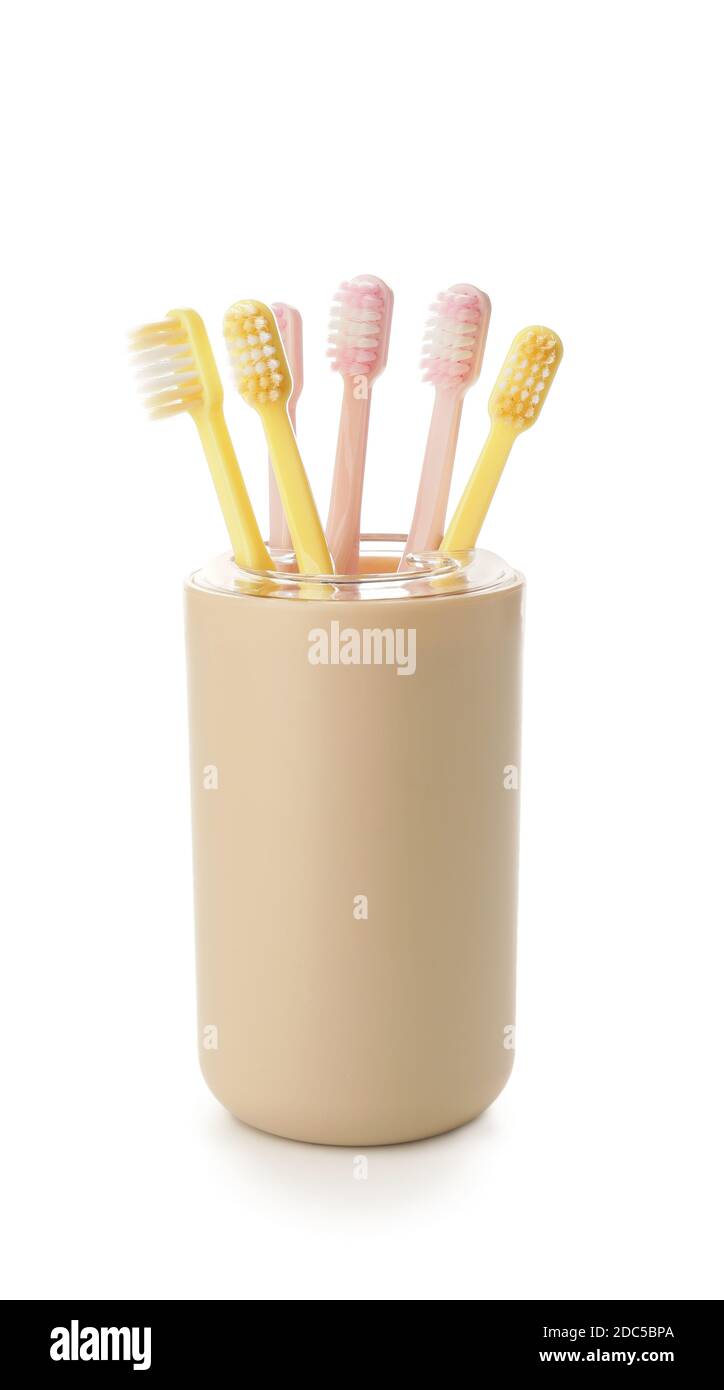 Cup with different toothbrushes on white background Stock Photo - Alamy