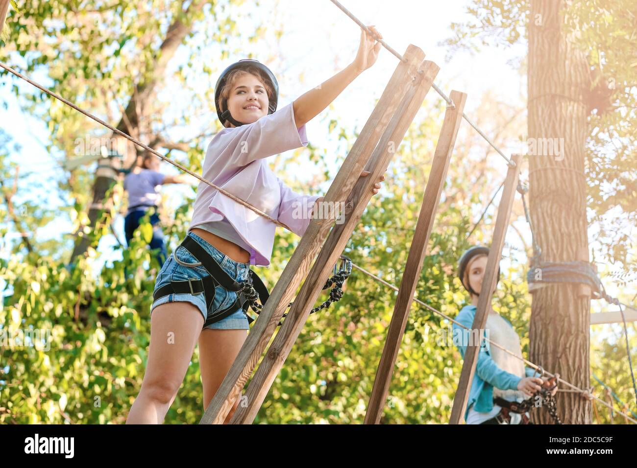 Teenage girl climbing in adventure park Stock Photo - Alamy