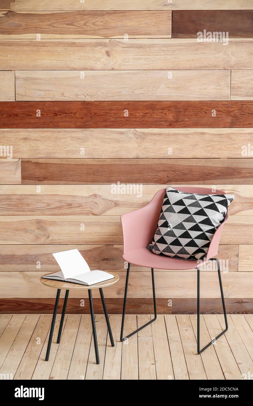 Chair and table near wooden wall in room Stock Photo - Alamy