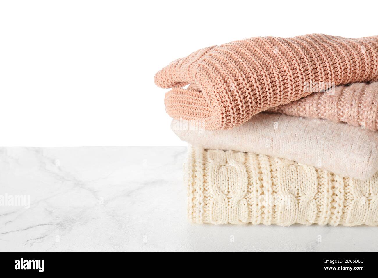 Stylish winter clothes on table against white background Stock Photo ...