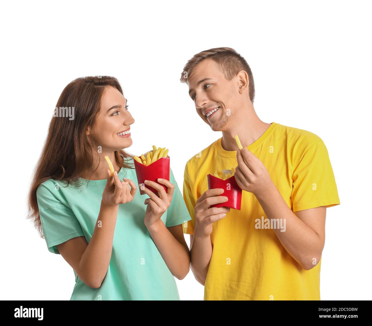 Young couple with french fries on white background Stock Photo - Alamy