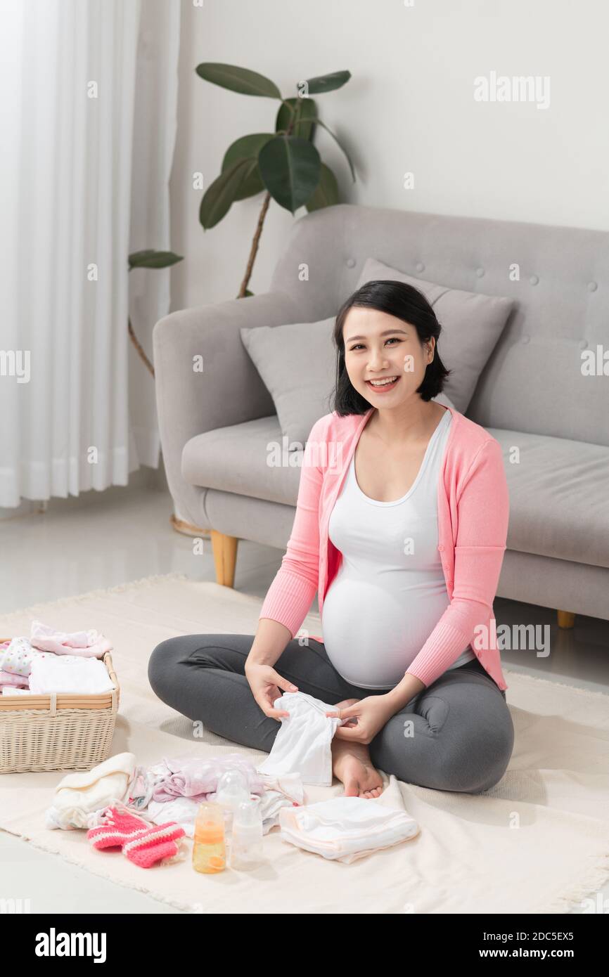 Asian mother preparing little clothes for new baby when sitting on the ...