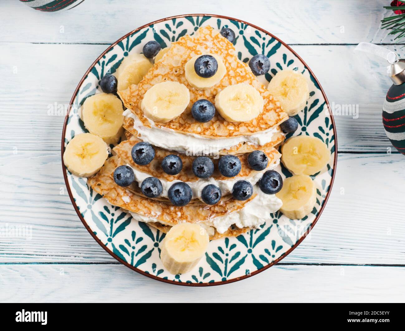 Christmas tree shaped crepes with quark, blueberry Stock Photo - Alamy