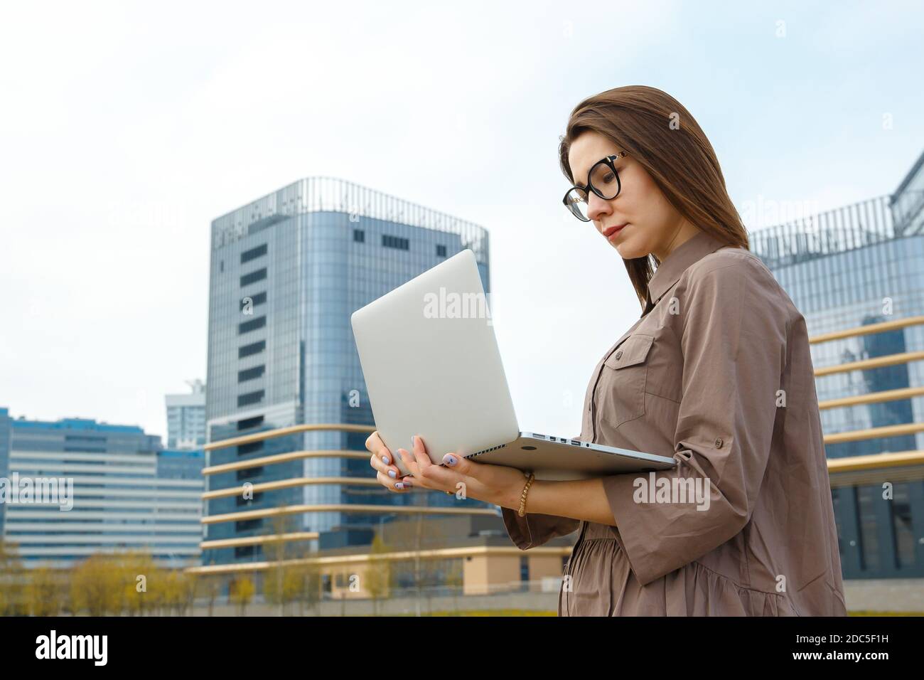 Business woman with computer on the background of a modern corporate ...