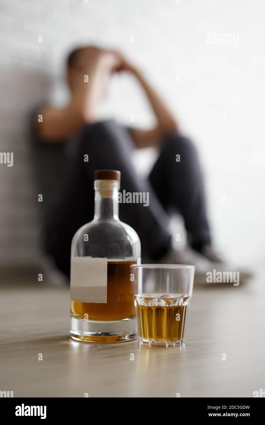 social problem concept - close up of whiskey bottle and glass and young ...