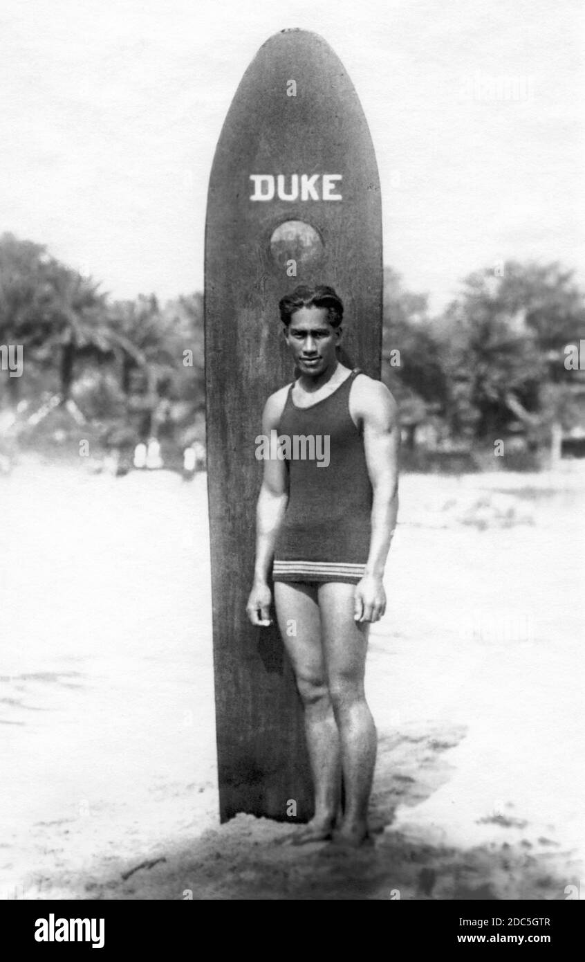 Duke Paoa Kahanamoku, the father of modern surfing, standing on a beach ...