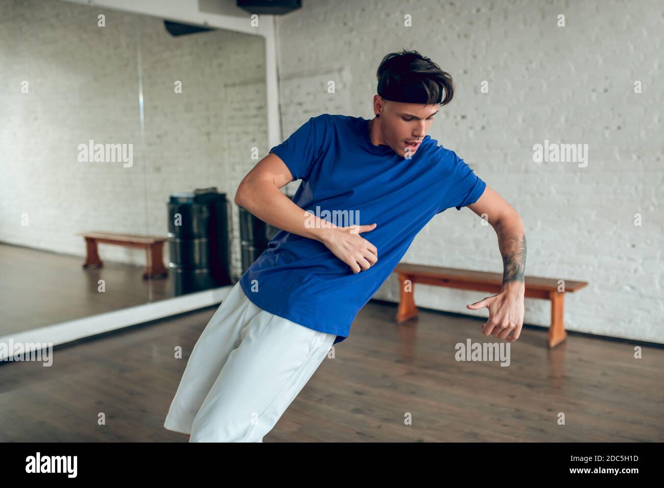 Concentrated man performing an isolation movement while dancing Stock ...