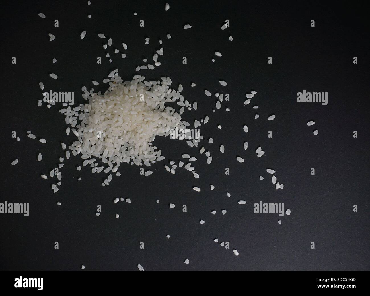 Scattered white uncooked rice in cereals on a black background Stock ...