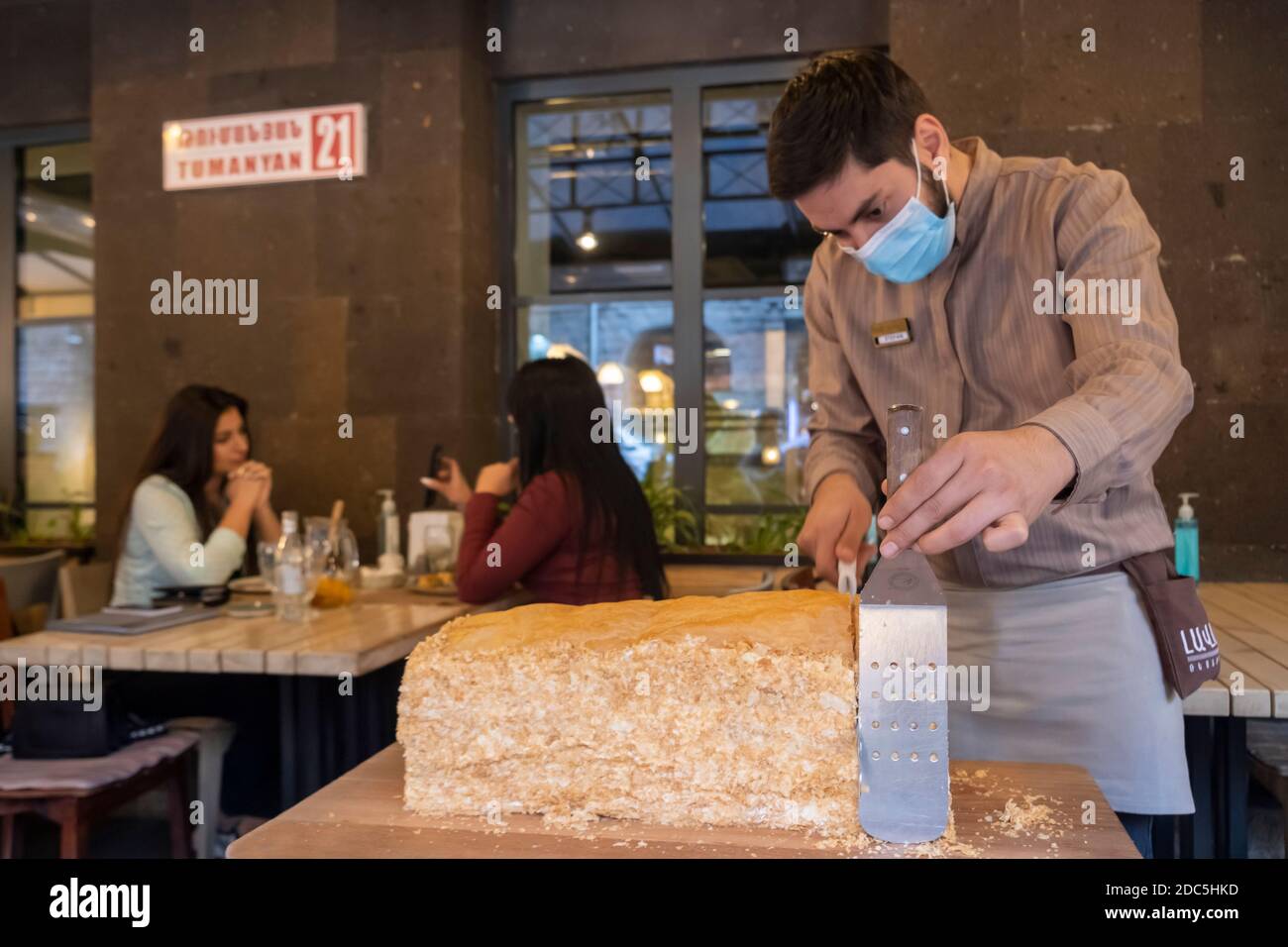 A waiter wearing protective mask due to the COVID-19 coronavirus ...