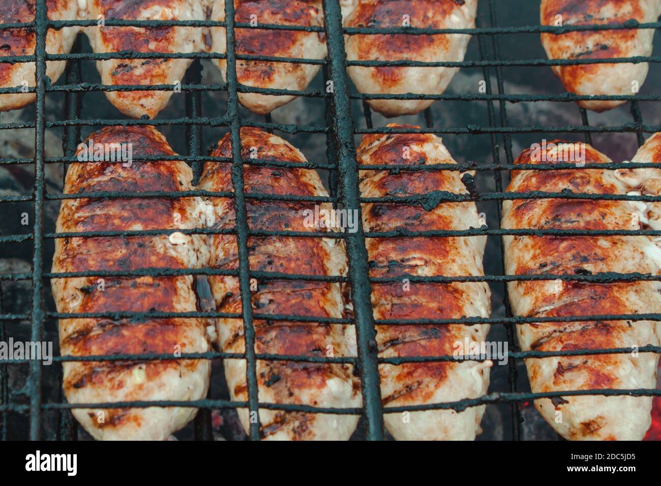 Kebab minced meat cooked on a grill in outdoor picnic. BBQ eating ...