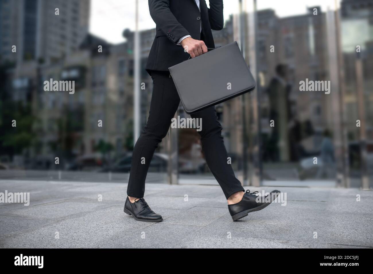 Close up picture of a man with portfolio in the street Stock Photo - Alamy