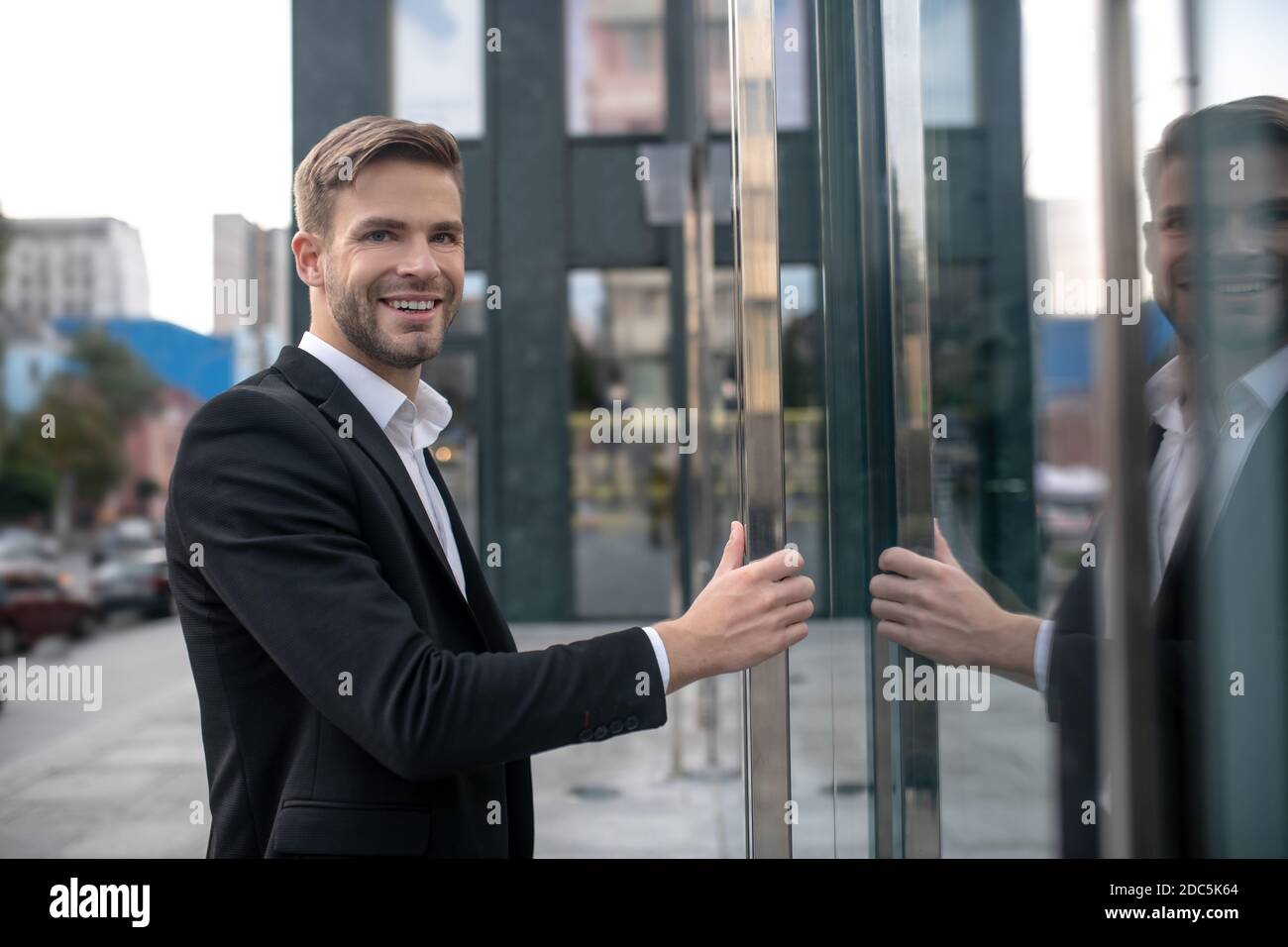 Elegant male businessman entering the business center and smiling Stock ...