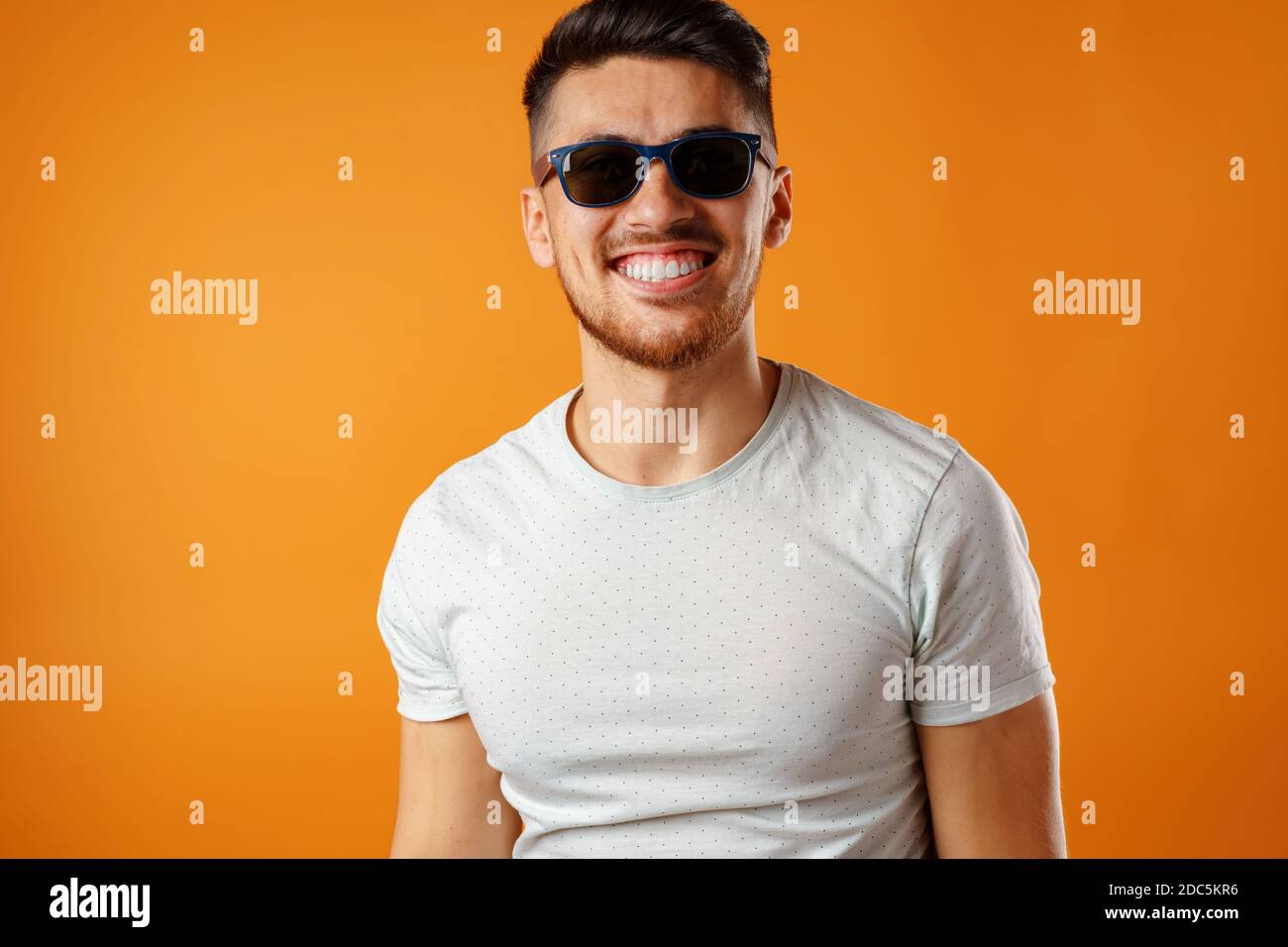 Cool smiling guy in black sunglasses and white shirt Stock Photo - Alamy