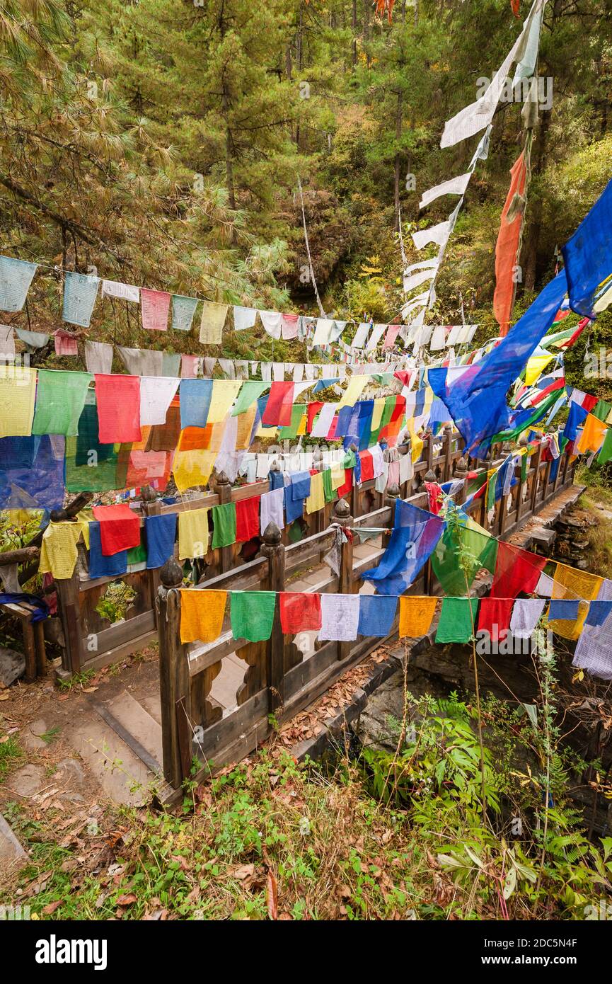Colourful traditional prayer flags decorate wooden bridge in Bhutan ...