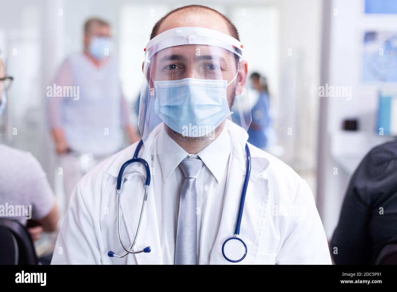 Portrait of tired medic in hallway of private hospital during ...