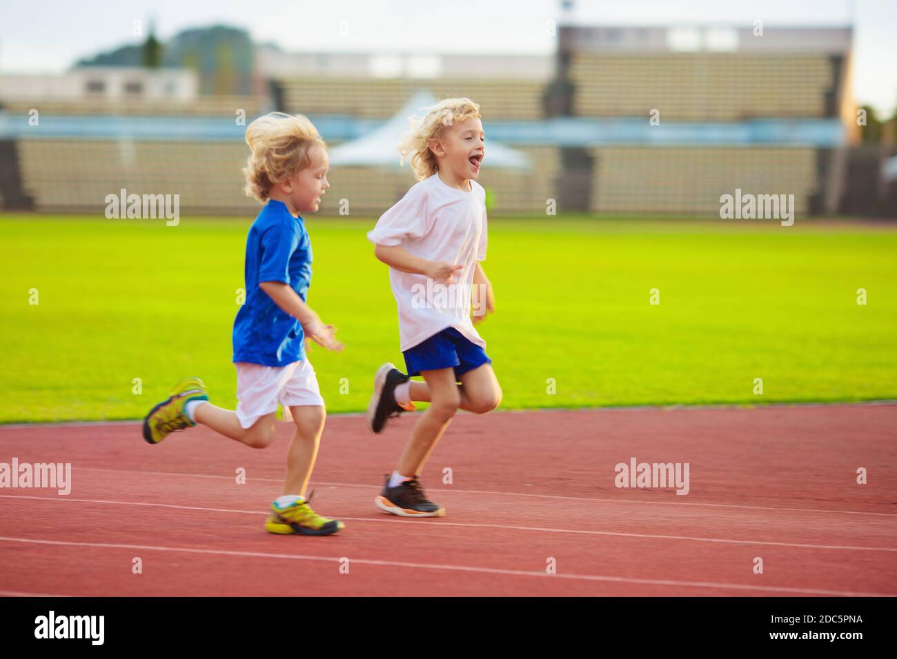 Child running in stadium. Kids run on outdoor track. Healthy sport ...