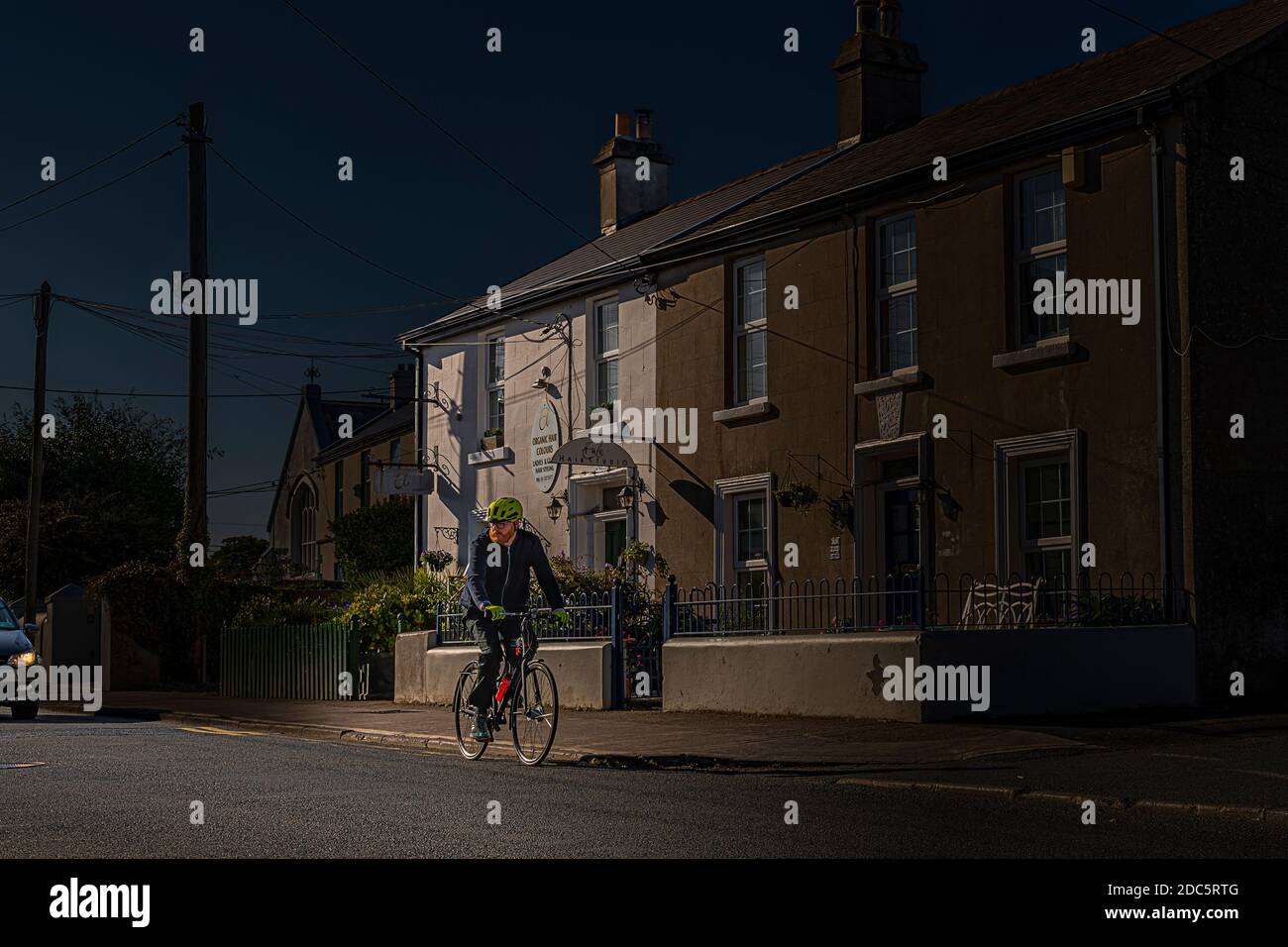 Everyday Life. Cyclist looking back at approaching car from behind ...