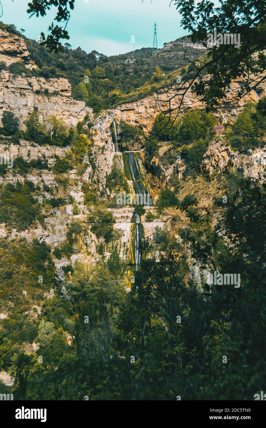 Landscape wit views of a waterfall flowing through the slope of a steep ...