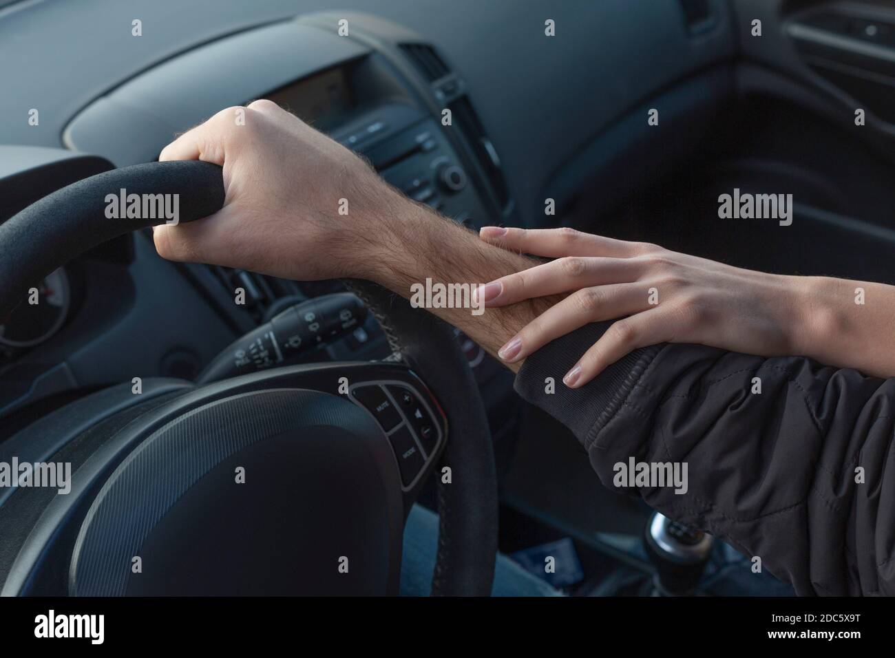 Woman touching arm of boyfriend driving car Stock Photo - Alamy