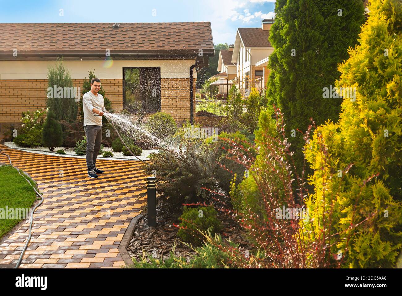 Man spraying plants with hose hi-res stock photography and images - Alamy