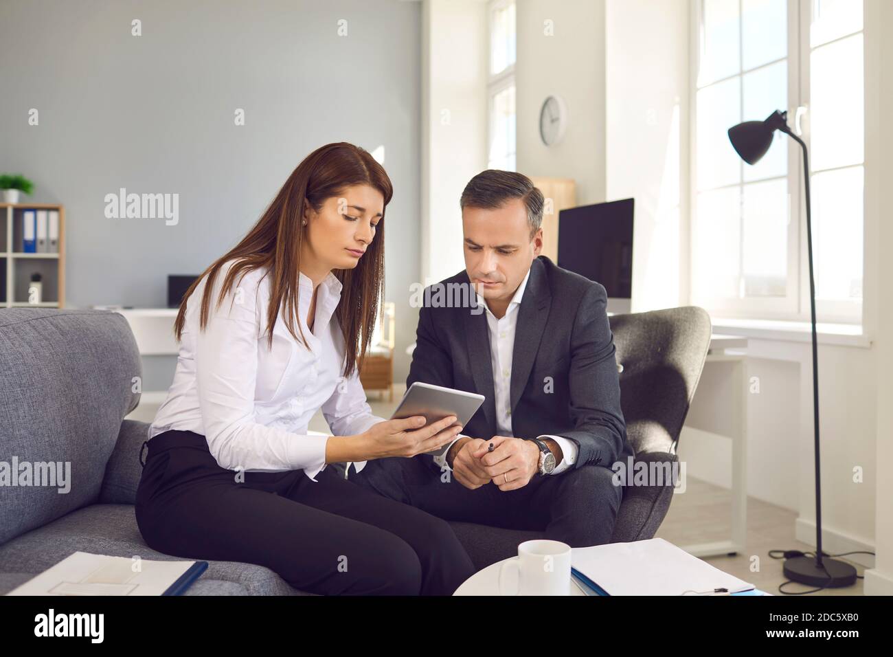 Female secretary with digital tablet in hands shows electronic ...